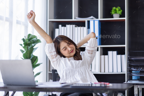 Tired Asian woman office employee staring at the laptop screen, feels ...