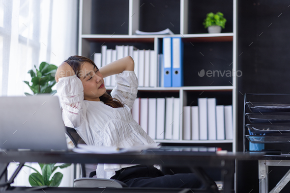 Tired Asian woman office employee staring at the laptop screen, feels ...