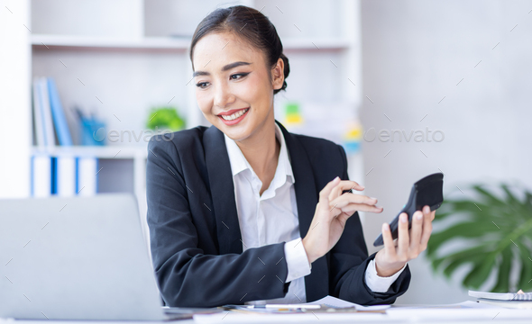 Asian female accountant or banker making calculations. Young business ...