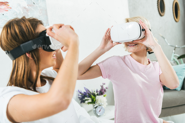 beautiful girls having fun and using virtual reality headsets at home ...