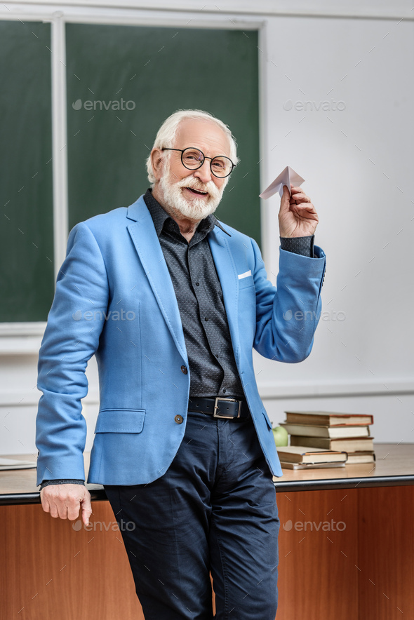 smiling grey hair professor holding paper plane in lecture room Stock ...