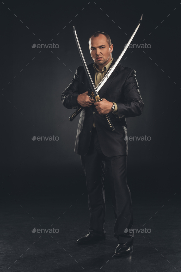 handsome man in suit with dual katana swords on black Stock Photo by ...