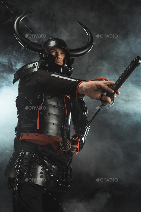 bottom view of samurai taking out his katana on dark background with ...