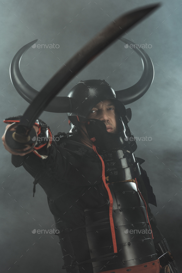 close-up shot of samurai in traditional armor with katana sword on dark ...