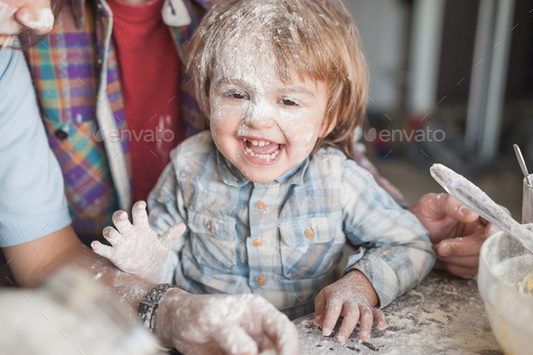 laughing little boy covered with flour while cooking with parents Stock ...
