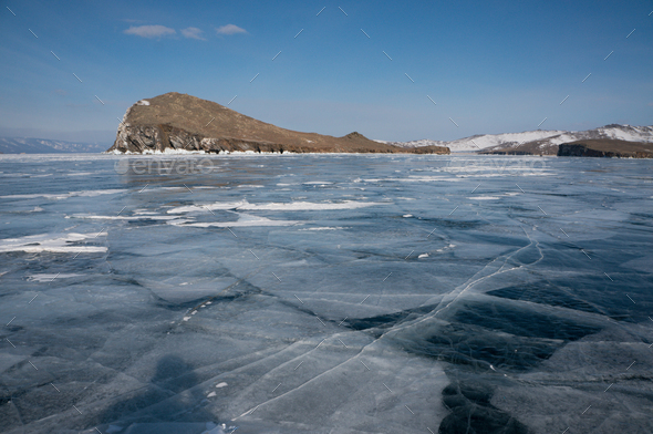 view of ice covered water surface of lake and rock formations on ...