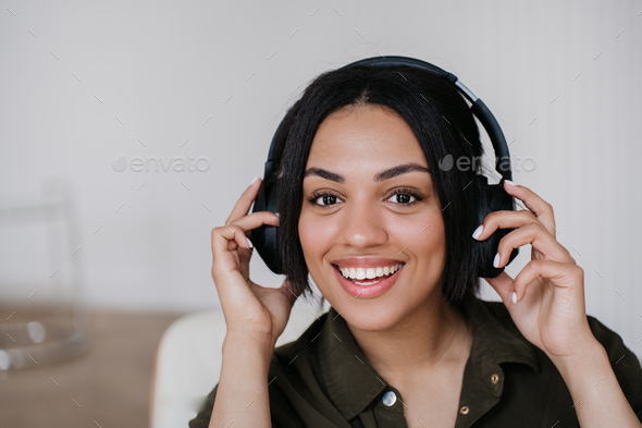 African american young woman in headphones toothy smiling holds headset ...