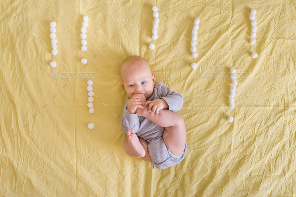 top view of adorable funny infant child lying surrounded with ...