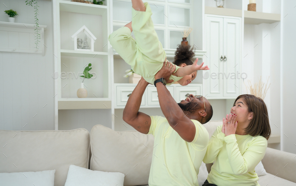 Parent having fun with his daughter by throwing up and lifting her up ...