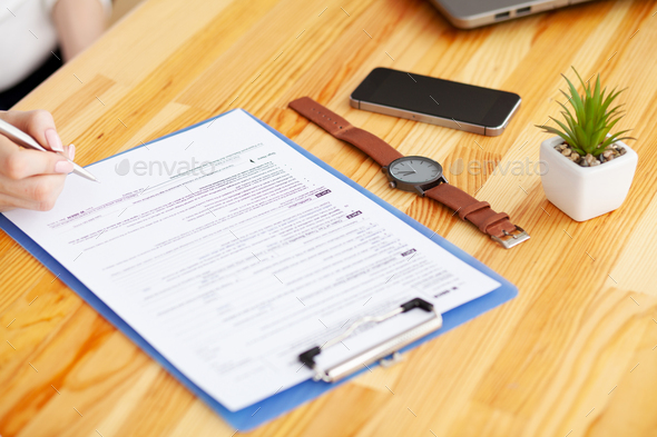 Contract. Blank of paper is on a wooden desk. Stock Photo by maksymiv