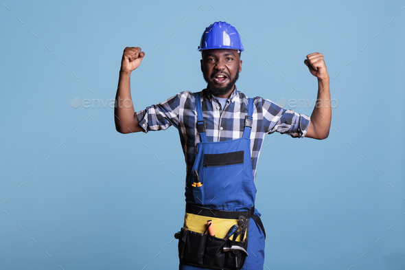 Construction worker showing his arm muscles Stock Photo by DC_Studio