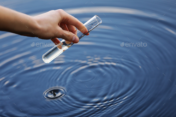 Water sample. Hand collects water to explore. Concept - water purity ...