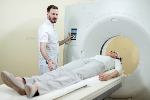 Radiologist preparing a patient for an MR scan examination at clinic ...