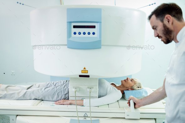Mature woman undergoing for abdomen MRI scan at clinic. Stock Photo by ...