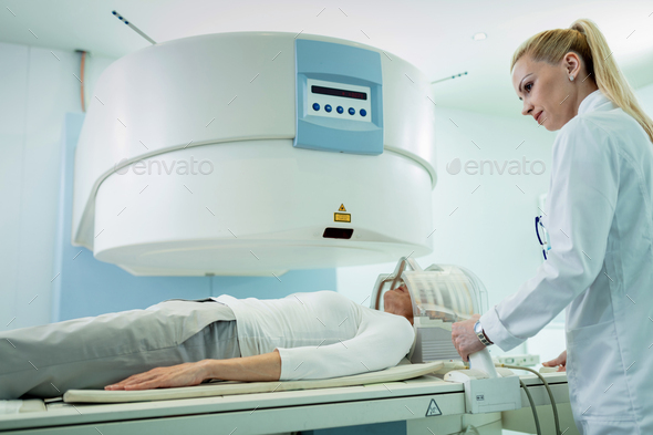 Female radiologist supervising patient during MRI scan in the hospital ...