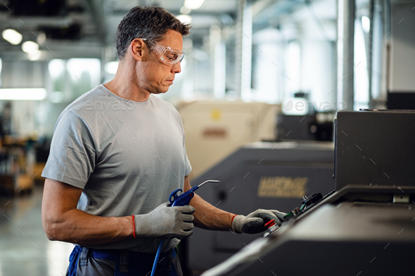 Manual worker working at CNC machine in industrial facility, Stock ...
