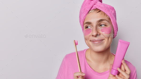 Pleased young woman smiles gently has dimples on cheeks holds ...