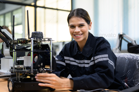 Female maintenance engineer checking and repairing automatic robotic ...