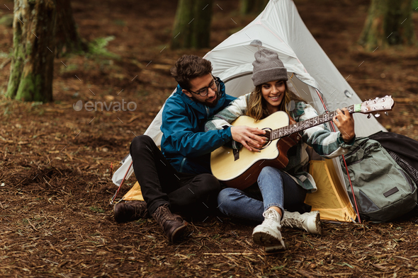 Cheerful millennial caucasian husband and wife in jackets sit in cold ...