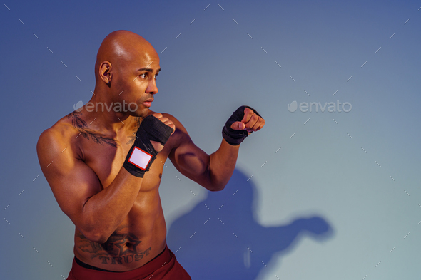 Professional kickboxer is training and practicing punch on studio ...