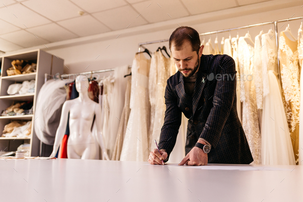 Male fashion designer creating a new collection of clothing Stock Photo ...