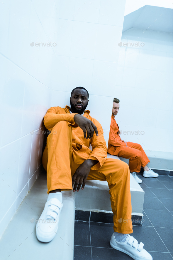 multicultural prisoners sitting on benches in prison cell Stock Photo ...