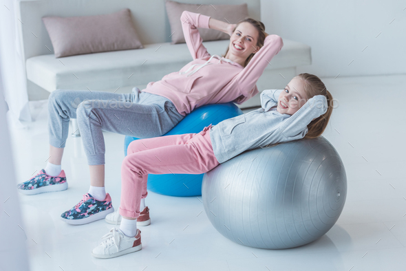 mother and daughter working out with fit balls at home Stock Photo by ...