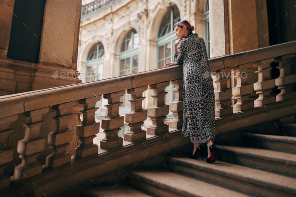 back view of beautiful pensive girl looking away while standing on ...