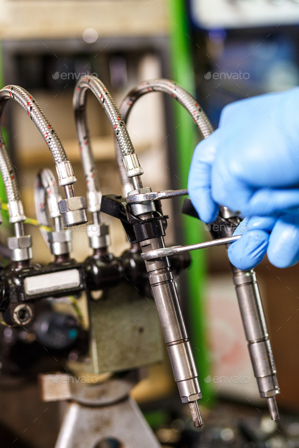 Professional mechanic testing diesel injector in his workshop. Stock ...