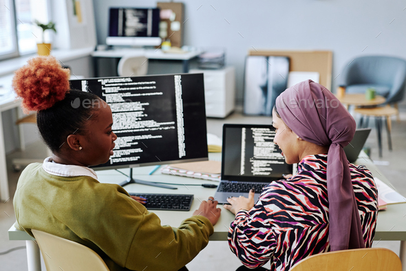Back view at two female programmers writing code together Stock Photo ...