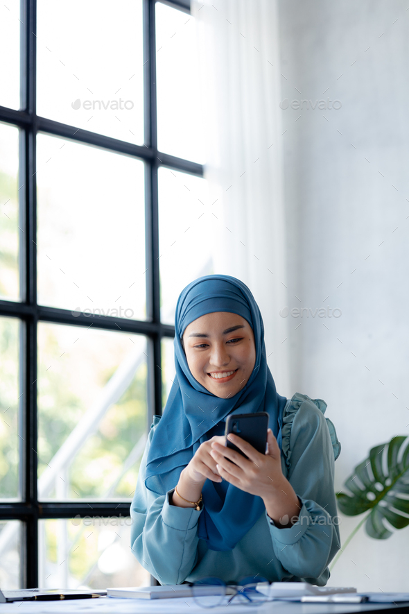 Asian women in hijab are using the mobile phone, administration and ...