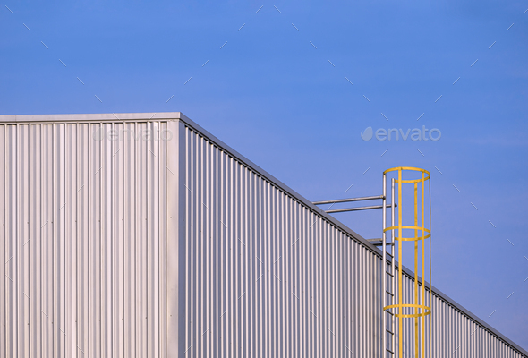 Corrugated iron Industrial Building Wall with cylinder Ladder against ...