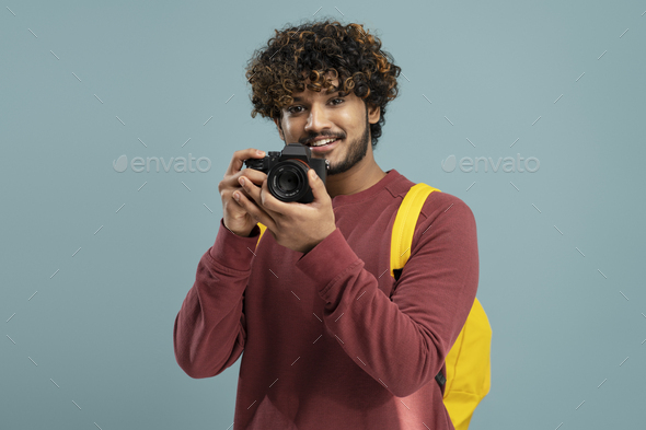 Smiling Asian guy photographer journalist, traveler holding digital ...