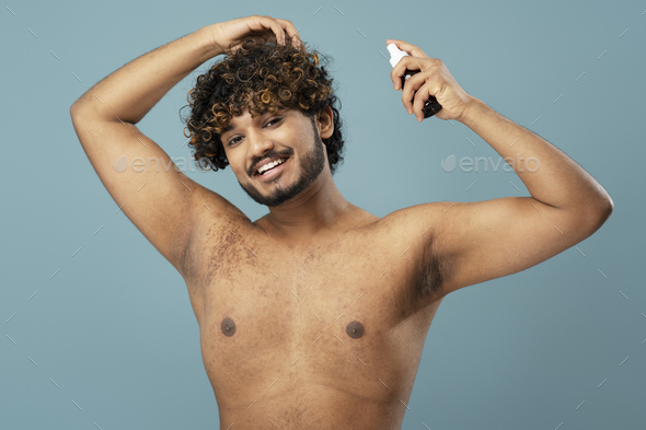 Attractive shirtless Indian man smilin at camera, applying hair care ...