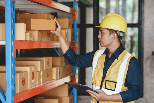Asian male supervisor worker inspecting warehouse checking stock ...