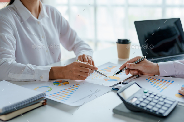 Business people in a meeting and using a calculator to calculate, plan ...