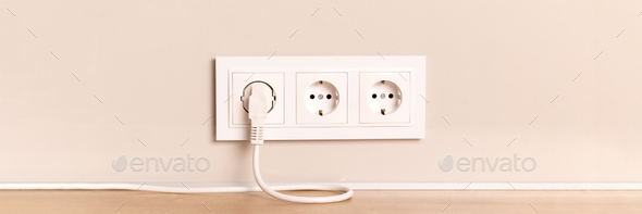 Electrical outlets with plug on beige wall banner Stock Photo by Bykfa