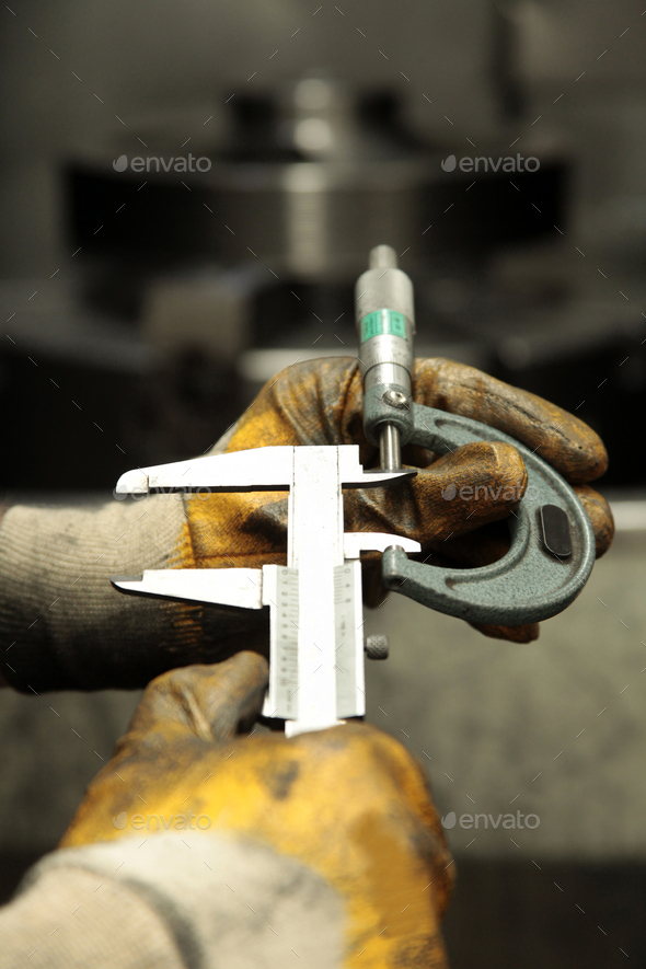 Metal measuring instruments in worker's hand. Vernier caliper ...