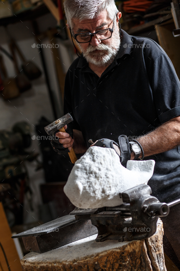 Senior sculptor working on his marble sculpture in his workshop with ...