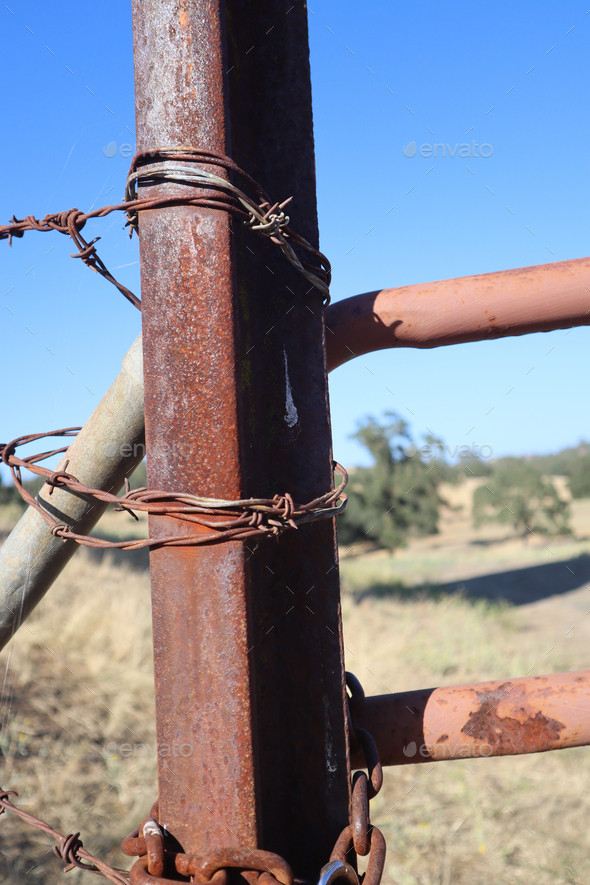 Vertical closeup of rusted gate fence post at a horse ranch in Amador ...