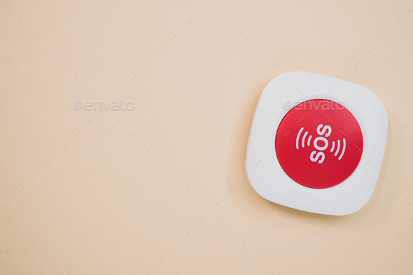 Top view of wireless SOS emergency alarm button isolated on light brown ...