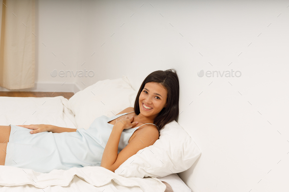 Healthy young woman dressing nightie lying on bed in bedroom Stock ...