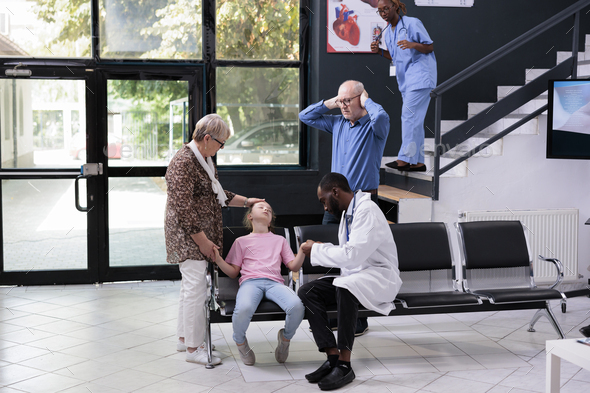 Unconscious little child falling on chair in hospital waiting area ...