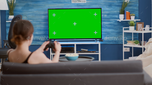 Young woman holding wireless controller playing action console video ...