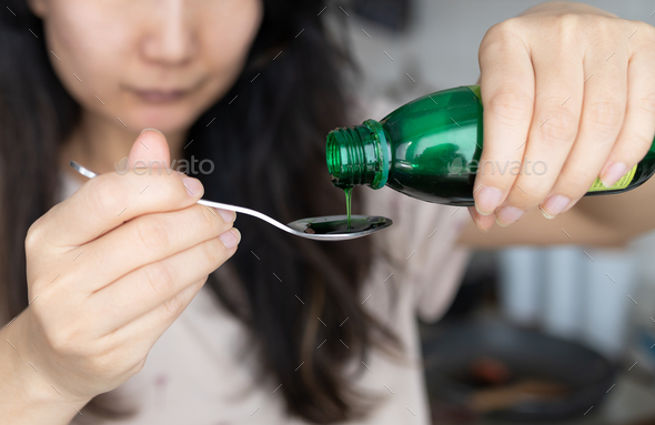 healthcare, people and medicine concept - Asian woman pouring medicine ...