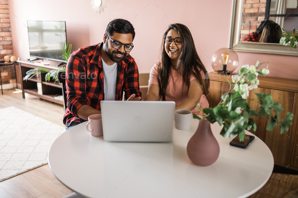 Happy indian family couple cuddle at desk make video call to friends ...