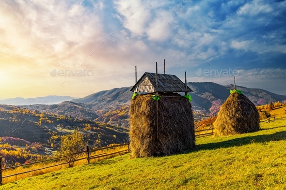 Haystack under wooden roof built behind fence in highland Stock Photo ...