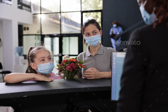 Reception worker talking with mother and kid explaining medical ...