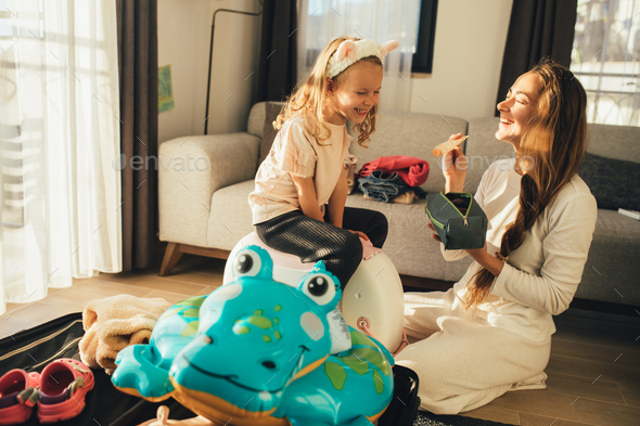 Mother and daughter packing before the trip. Stock Photo by Polinalebed