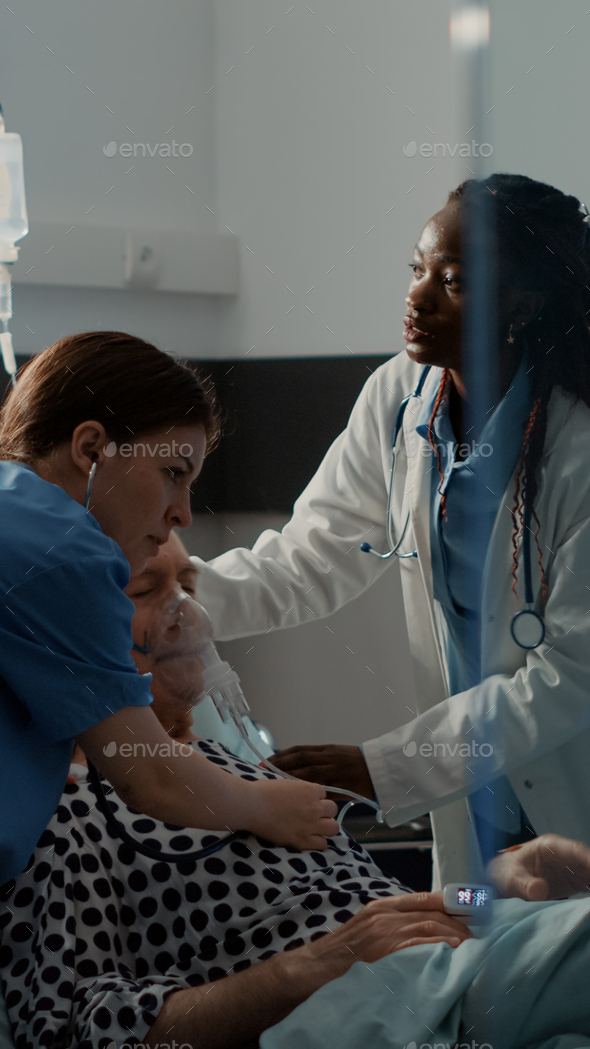 Elder patient breathing heavy in hospital ward bed Stock Photo by DC_Studio